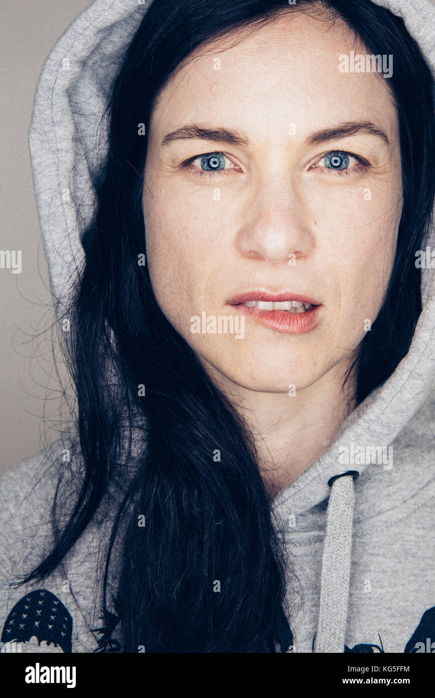 Woman with hood pullover, doubtful, portrait Stock Photo - Alamy