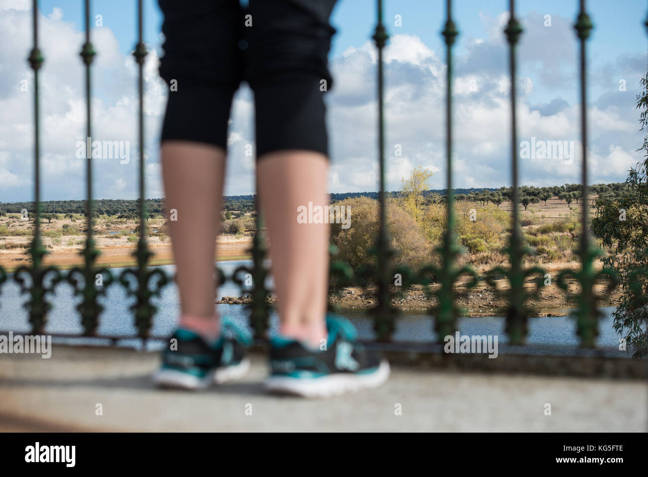 Sporty woman legs on a balcony over a beautiful landscape in ...