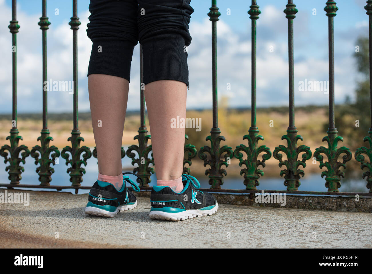 Sporty woman legs on a balcony over a beautiful landscape in ...