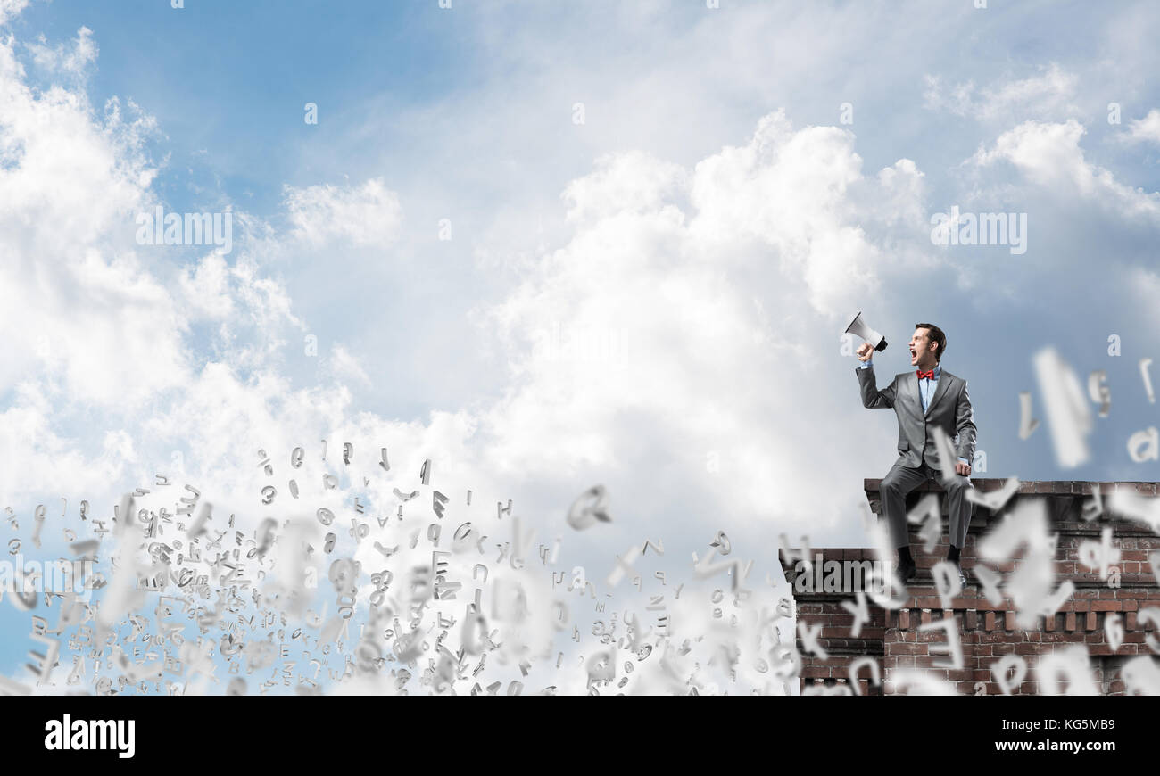 Young businessman sitting on bench and screaming emotionally in ...