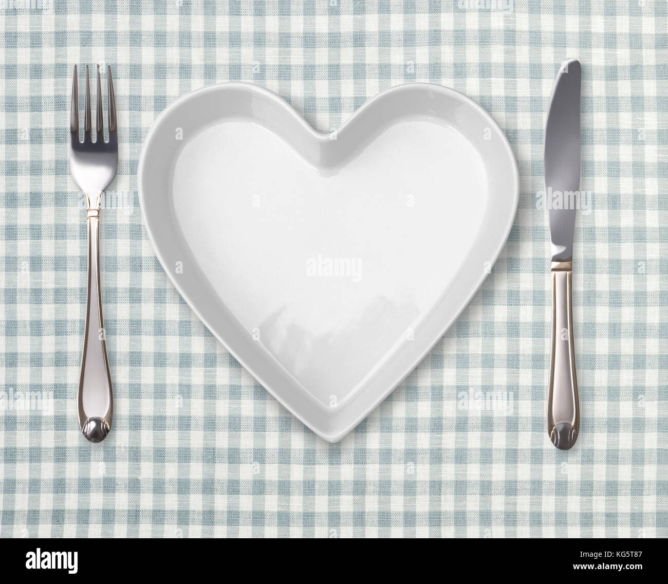 Table appointments with heart-shaped plate. Template with empty plate ...