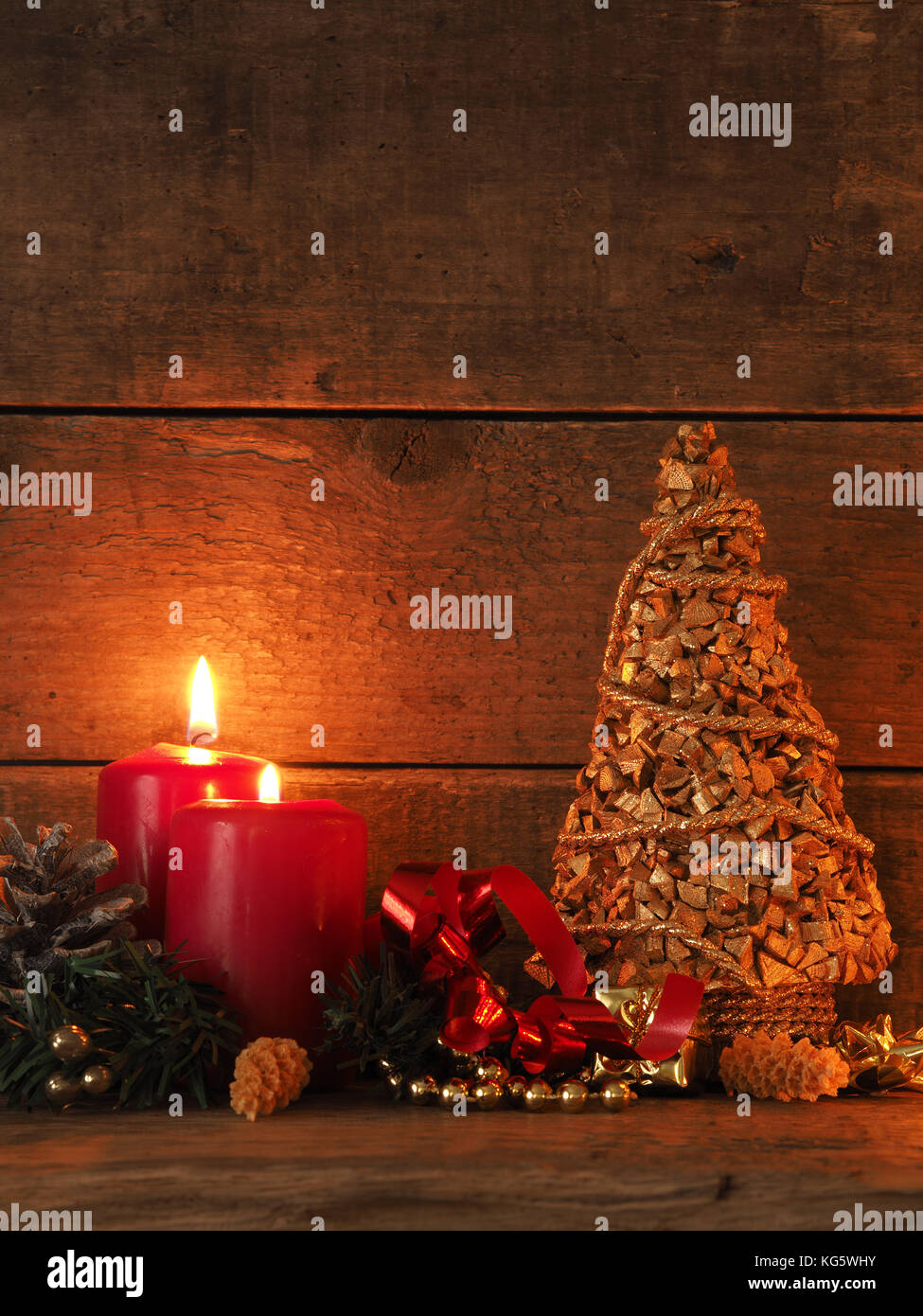 Romantic Christmas background with two candles and a golden tree on a ...