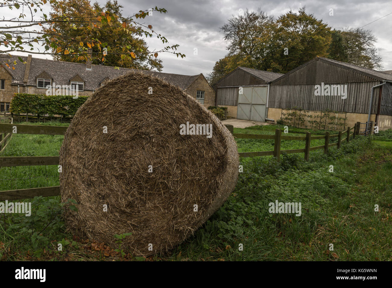 Round hay bale outside some barns Stock Photo - Alamy