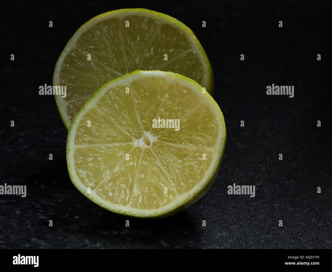Lime still-life on black background Stock Photo - Alamy