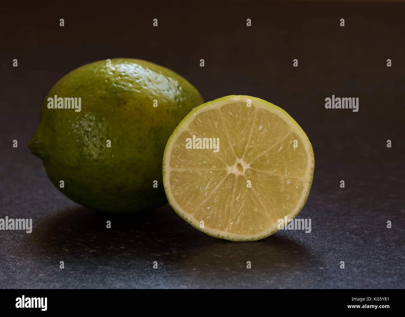 Lime still-life on black background Stock Photo - Alamy