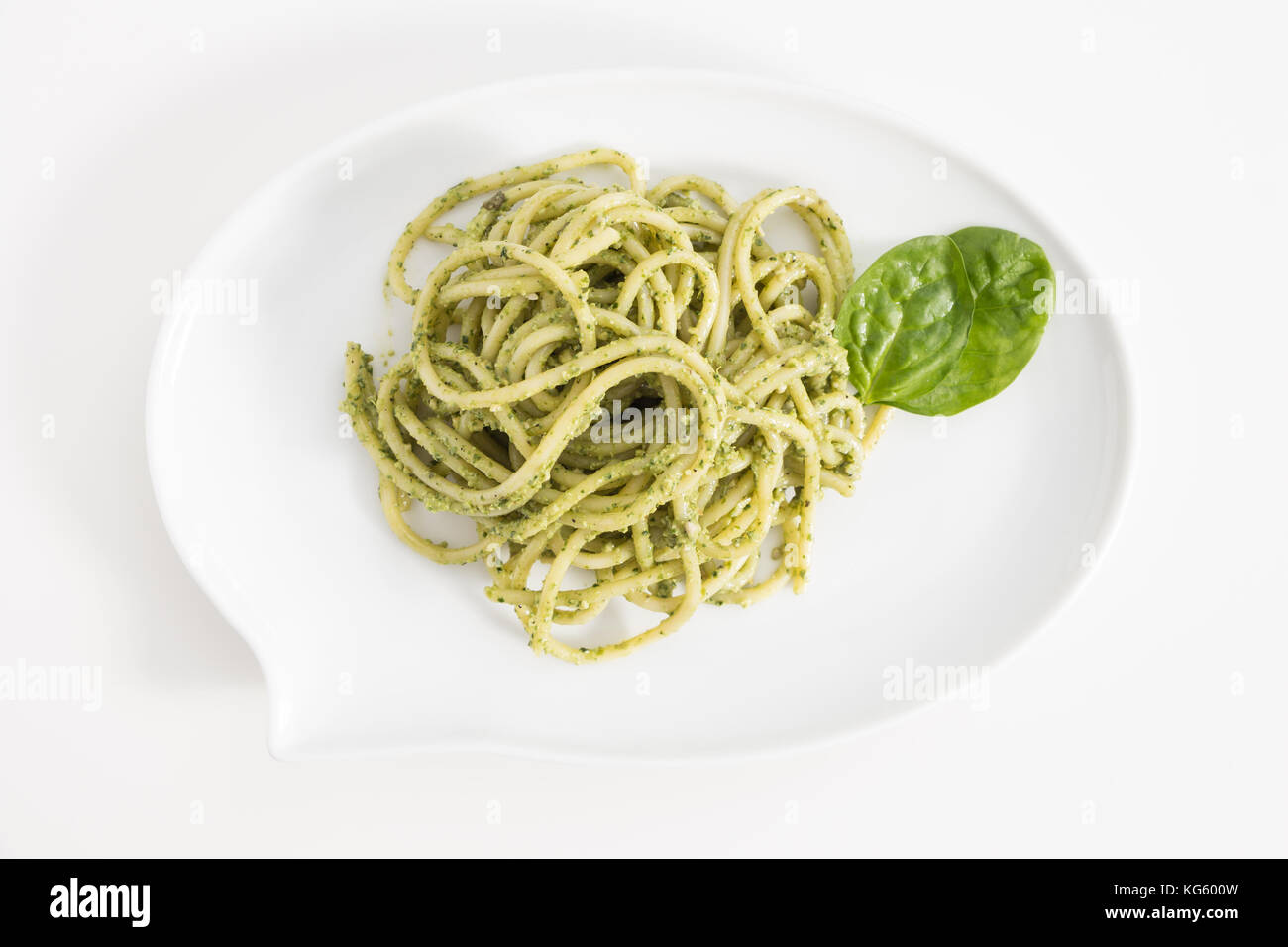 Spaghetti pasta with pesto sauce in white dish in shape of a chat ...