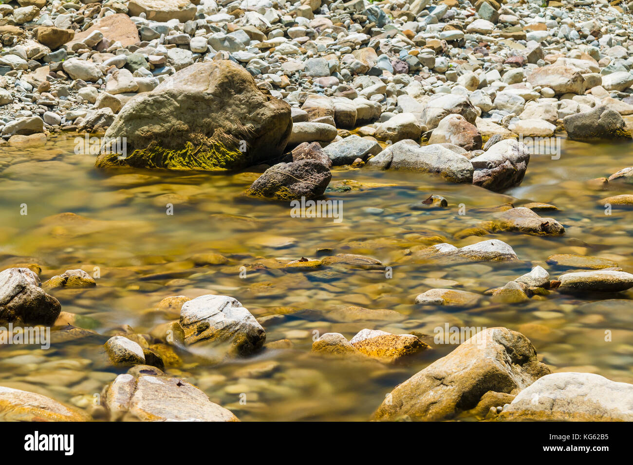 Long exposure photo of the river flowing in rocky ravine in sunny day ...
