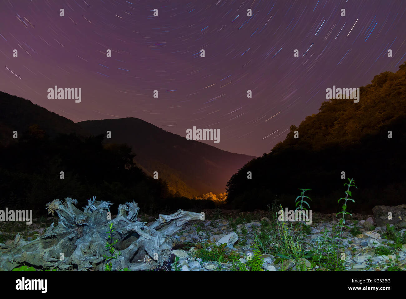 Long exposure photo of night landscape of ravine, mountains and star ...