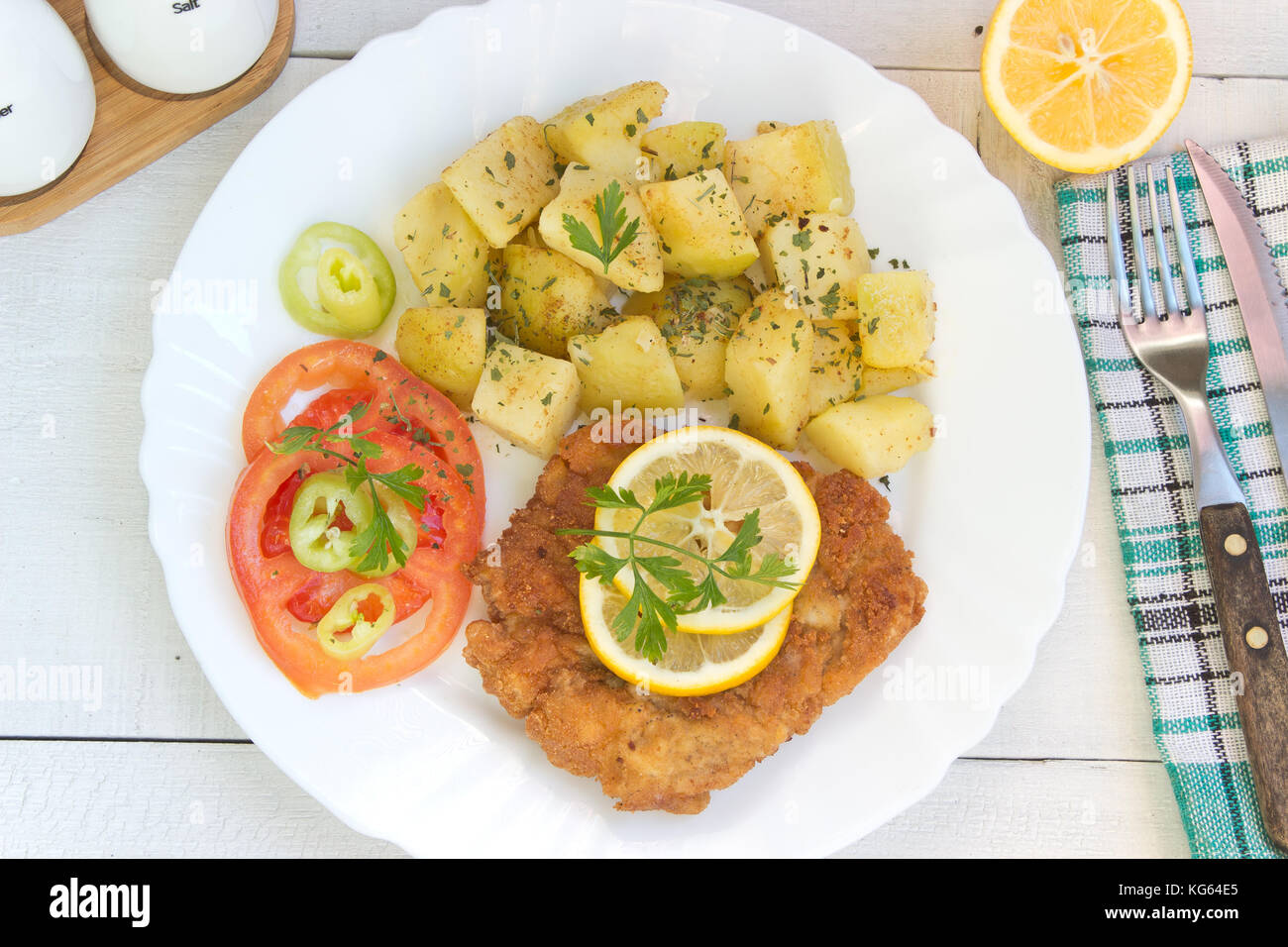 Wiener schnitzel with potatoes in plate on table Stock Photo - Alamy