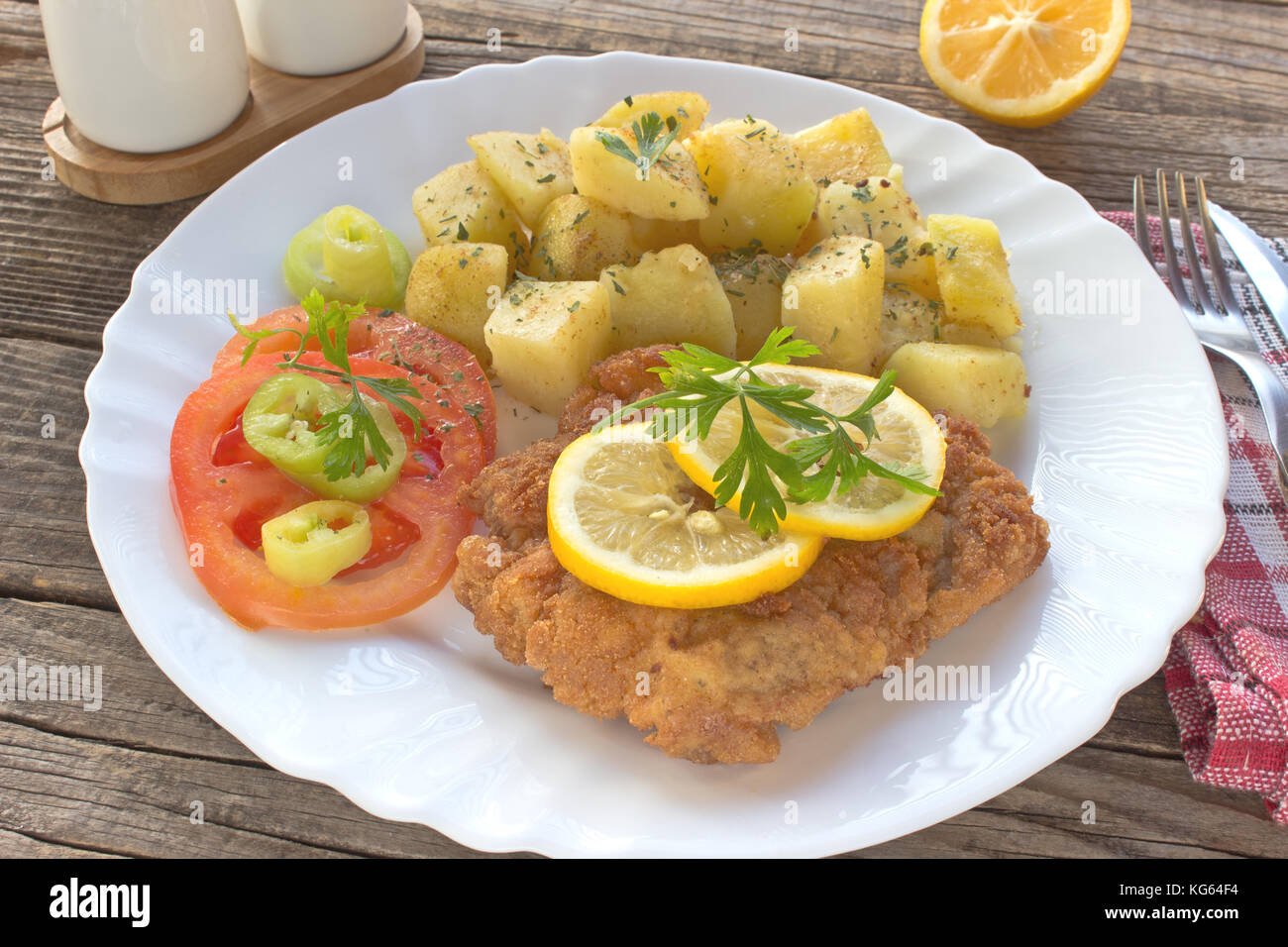 Wiener schnitzel with potatoes in plate on table Stock Photo - Alamy