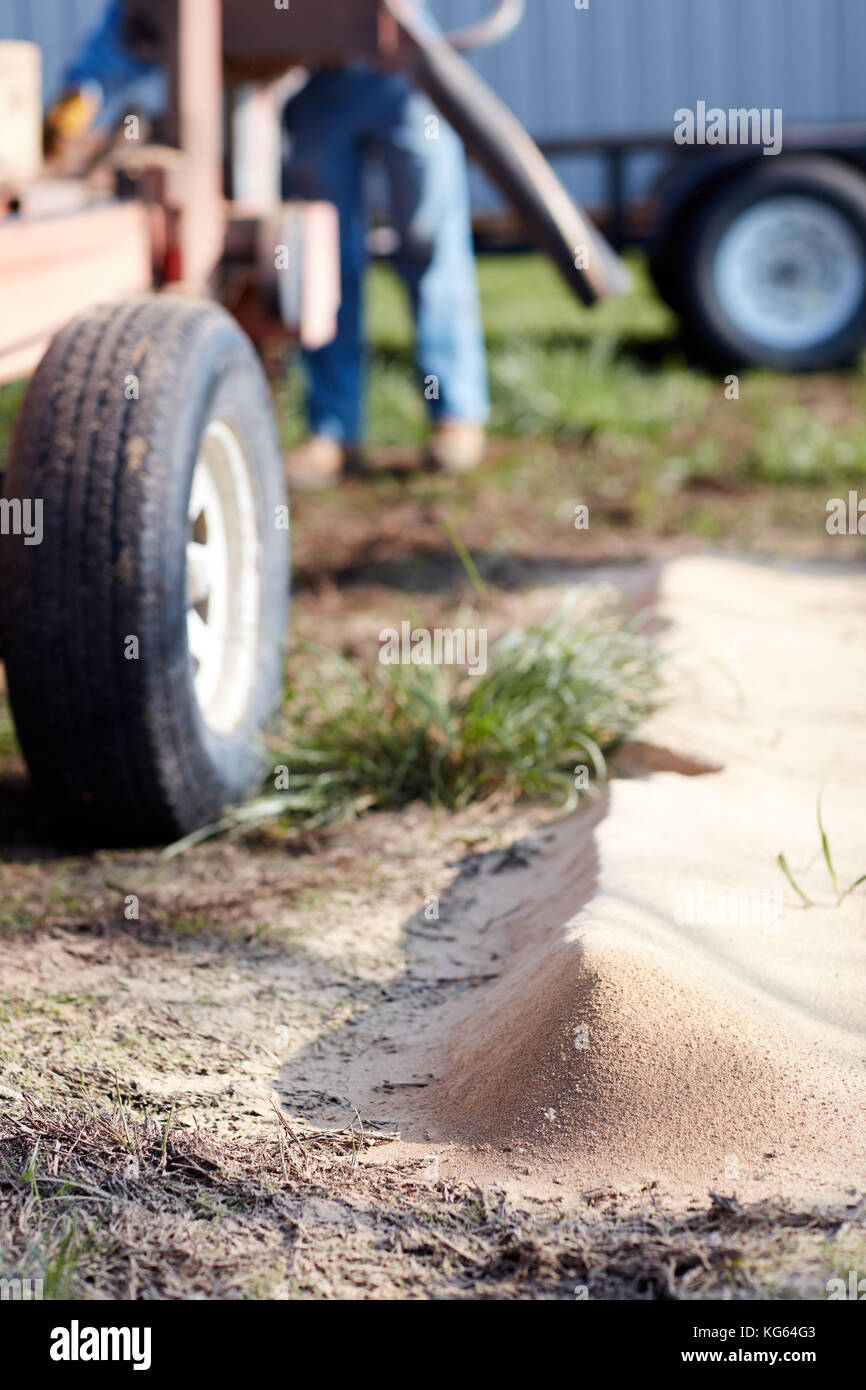 Pile of fresh sawdust on the ground alongside a portable industrial ...
