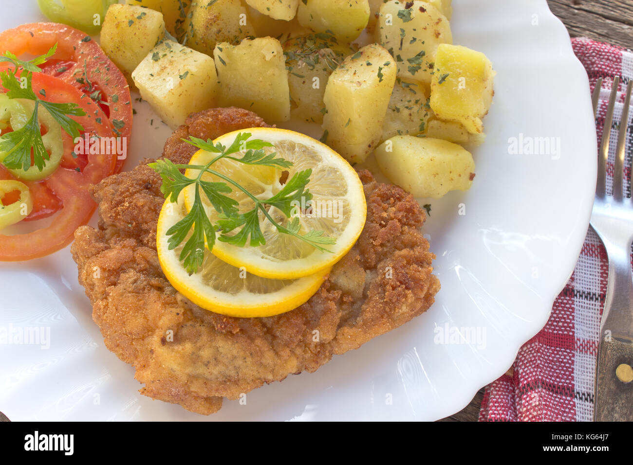 Wiener schnitzel with potatoes in plate on table Stock Photo - Alamy