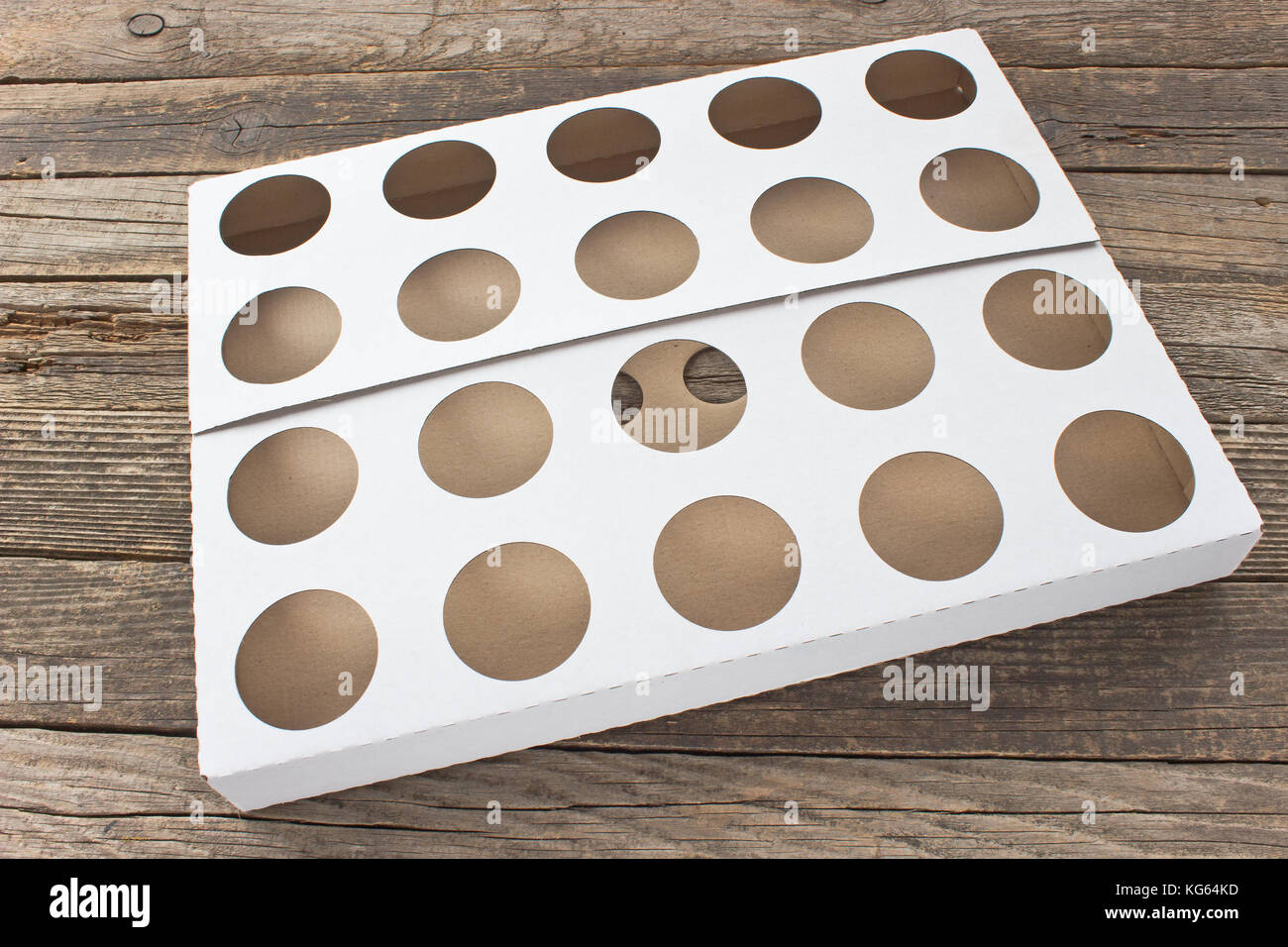 Cardboard box with holes on wooden background Stock Photo - Alamy