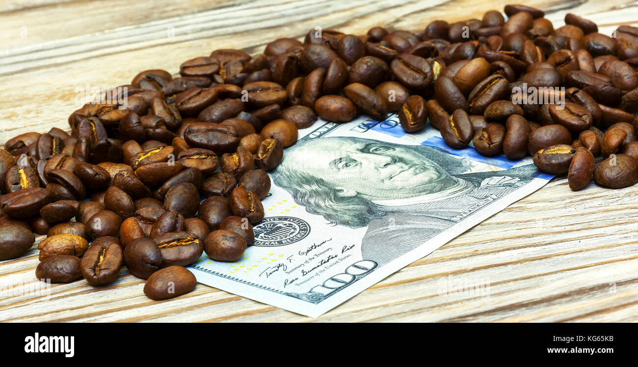 On a wooden background is a money bill and coffee beans Stock Photo - Alamy