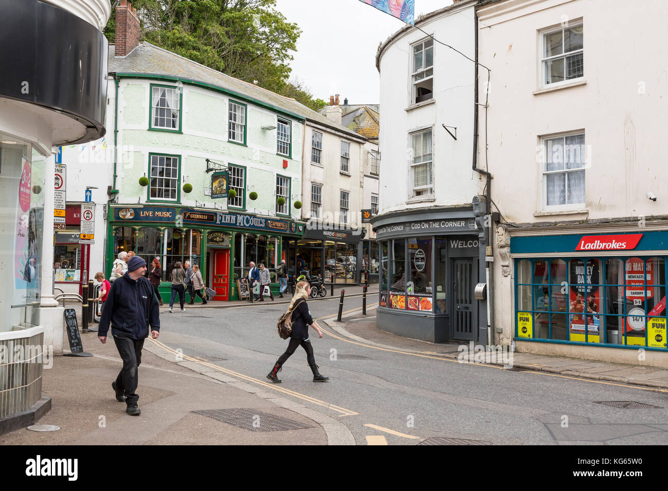girl crossing road in British town high street Stock Photo - Alamy