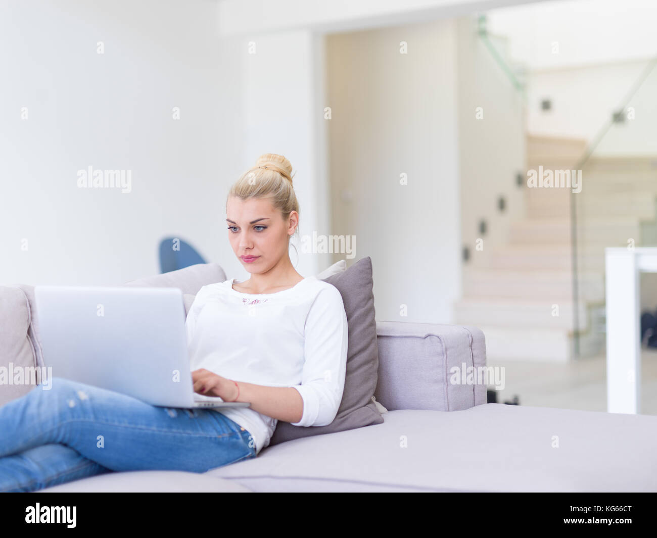 Young woman using her laptop computer in her luxury modern home ...