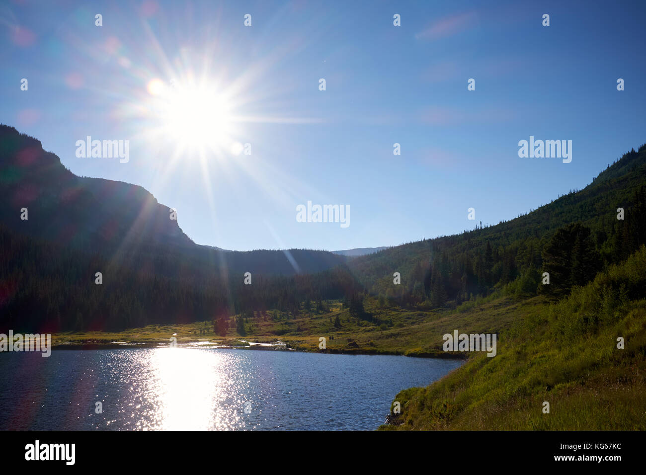 Bright sunburst over a tranquil Colorado mountain lake in the Flat Tops ...