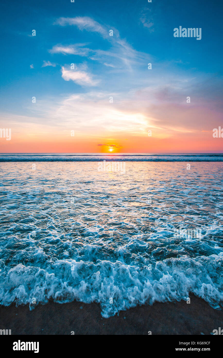 Splashing ocean wave in front of beautiful sunset sky background Stock Photo - Alamy