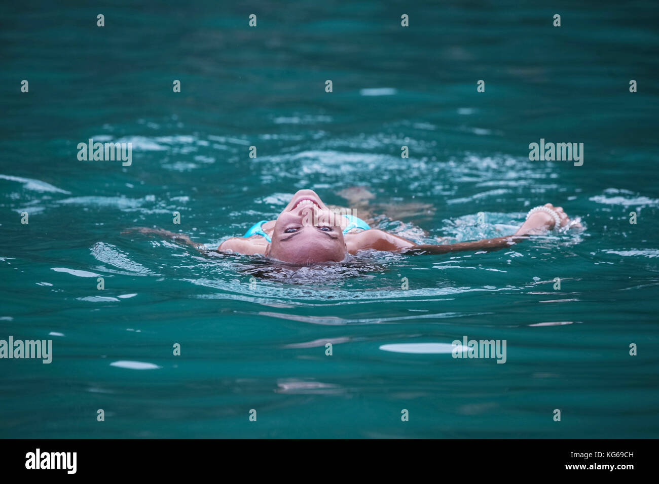 Young woman lying on her back floating in tropical sea water Stock ...