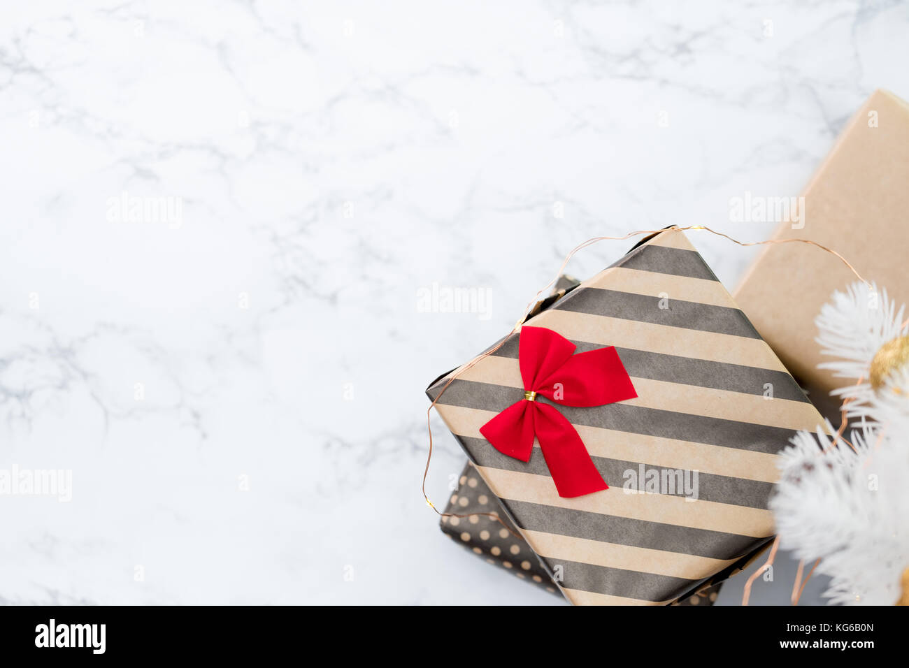 Top view of modern striped present box with red bow lay under white ...