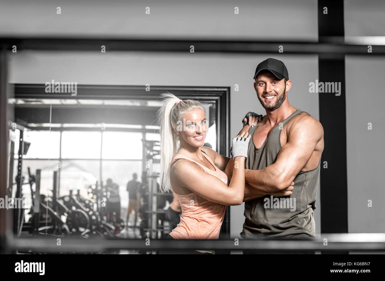 Young fitness couple in 20s standing together in modern fitness center ...