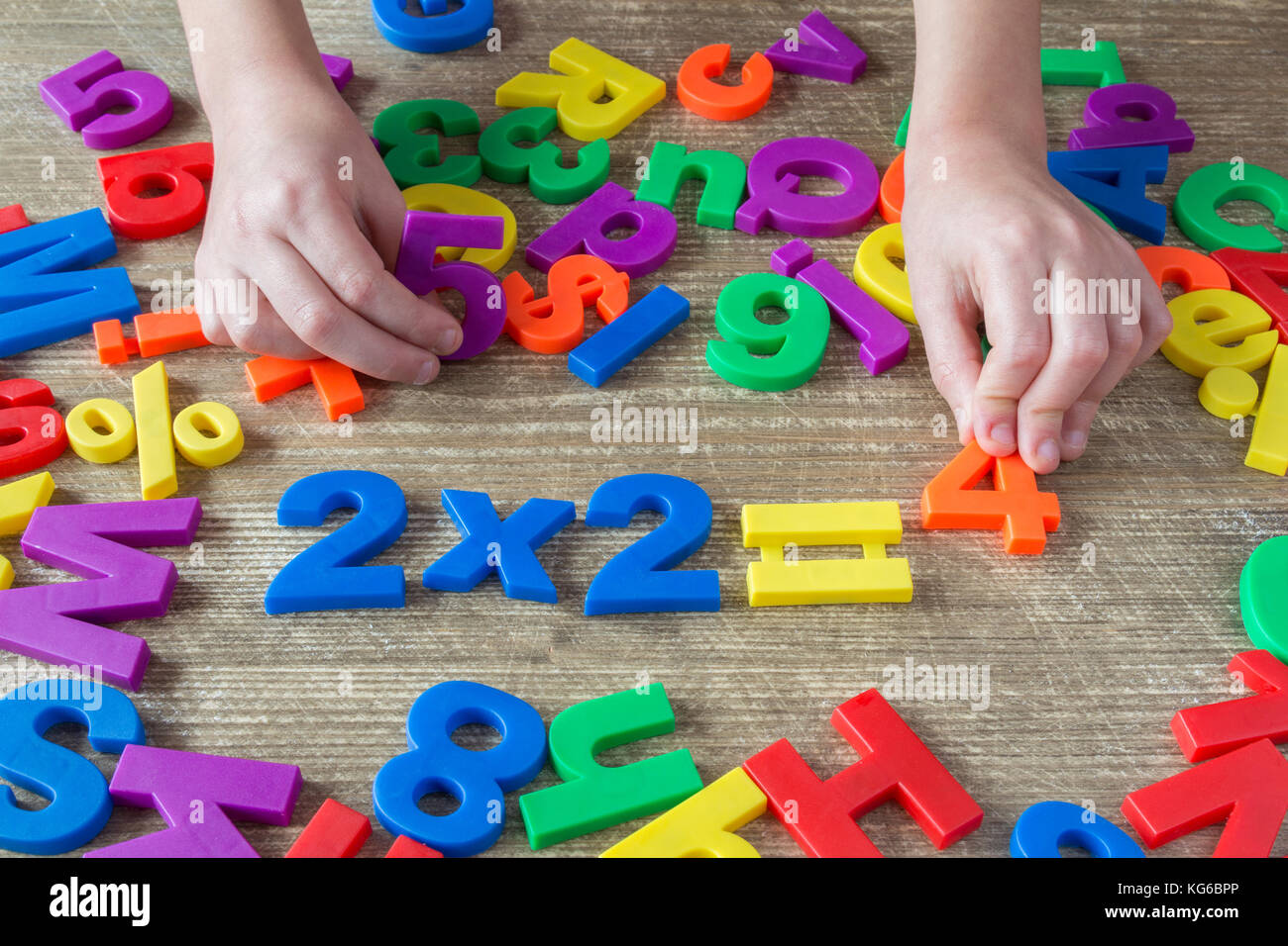 Child's hands playing with numbers, learning simple multiplication ...