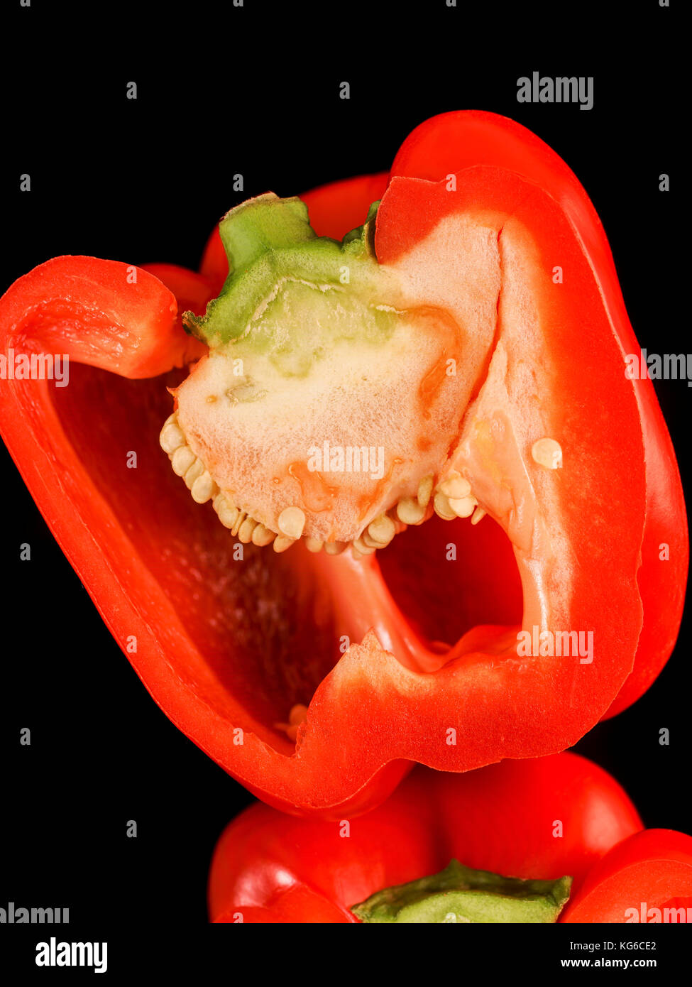 Half of red pepper still-life on black background Stock Photo - Alamy
