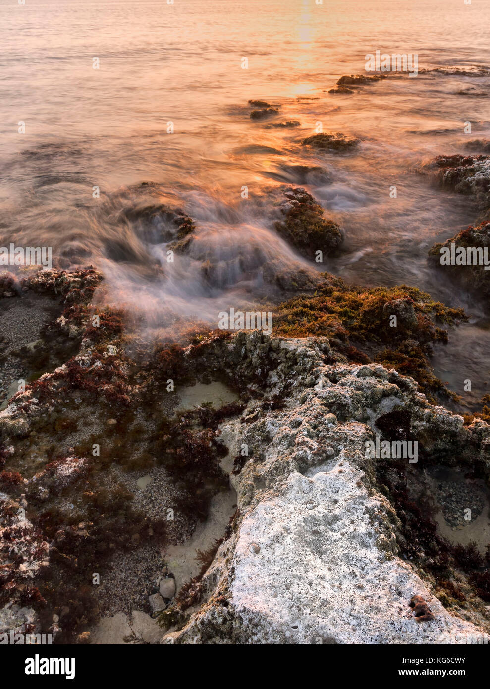 White rock jutting out into sunset sea, Paphos harbour, Paphos, Cyprus ...