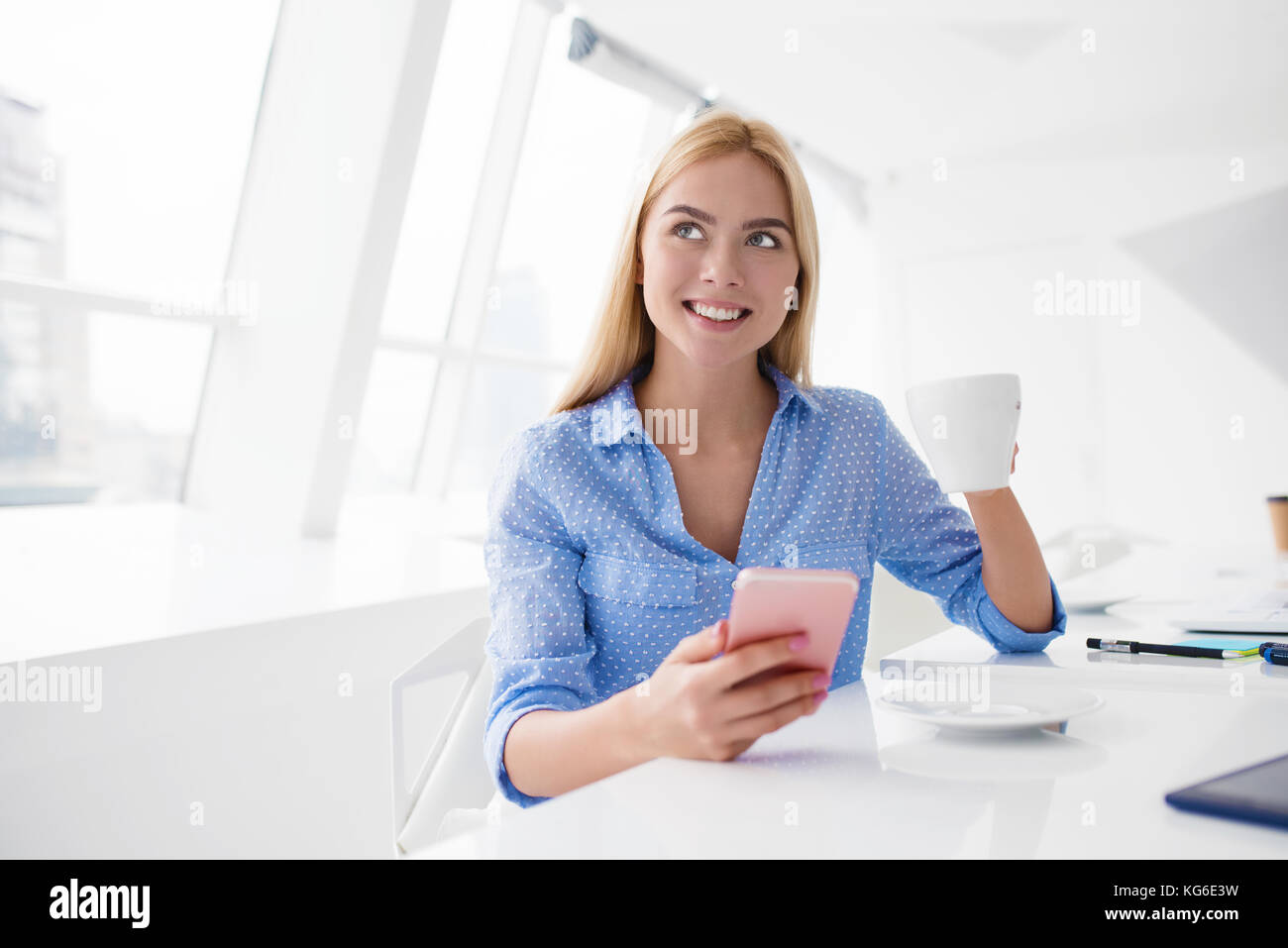 Happy woman takes a coffee break during her work Stock Photo - Alamy
