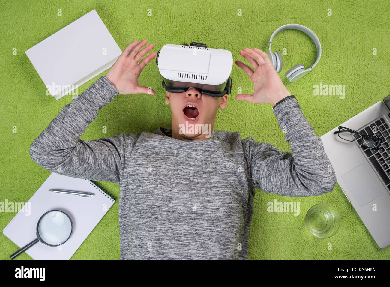 Top view of asian man wearing virtual reality goggles. Man lying on the ...
