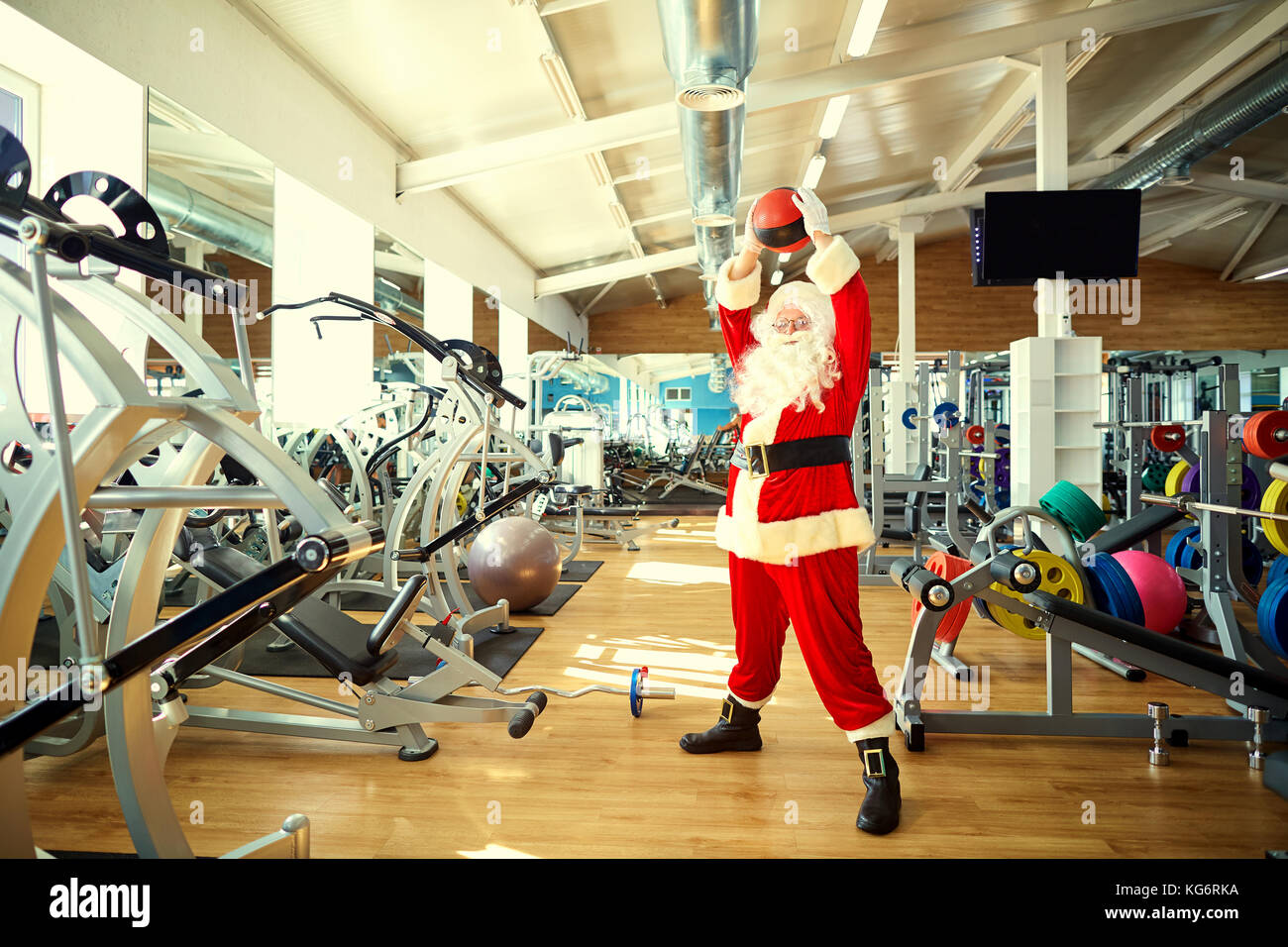 Santa Claus with dumbbells in the gym for Christmas Stock Photo - Alamy