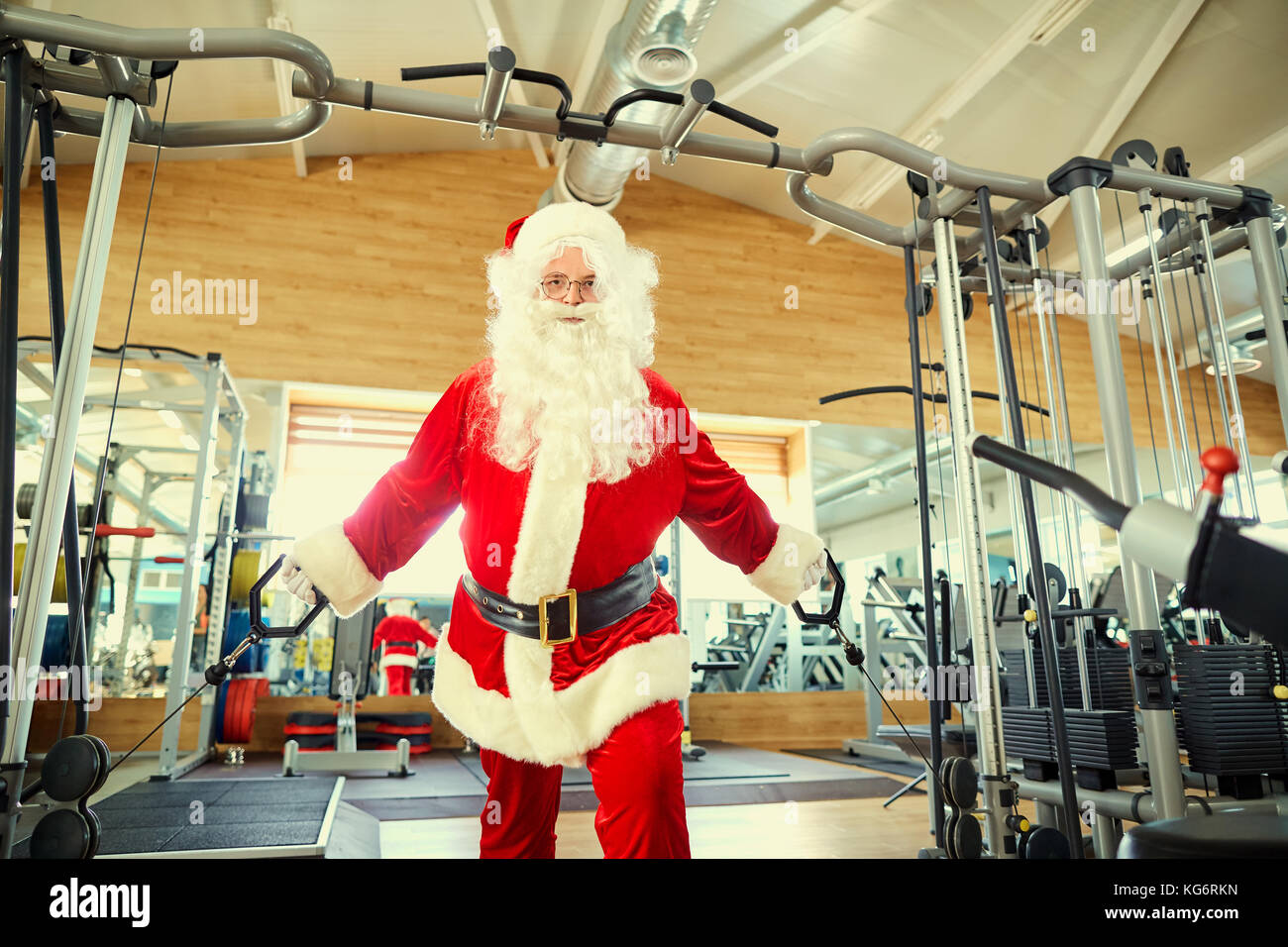 Santa Claus with dumbbells in the gym for Christmas Stock Photo - Alamy