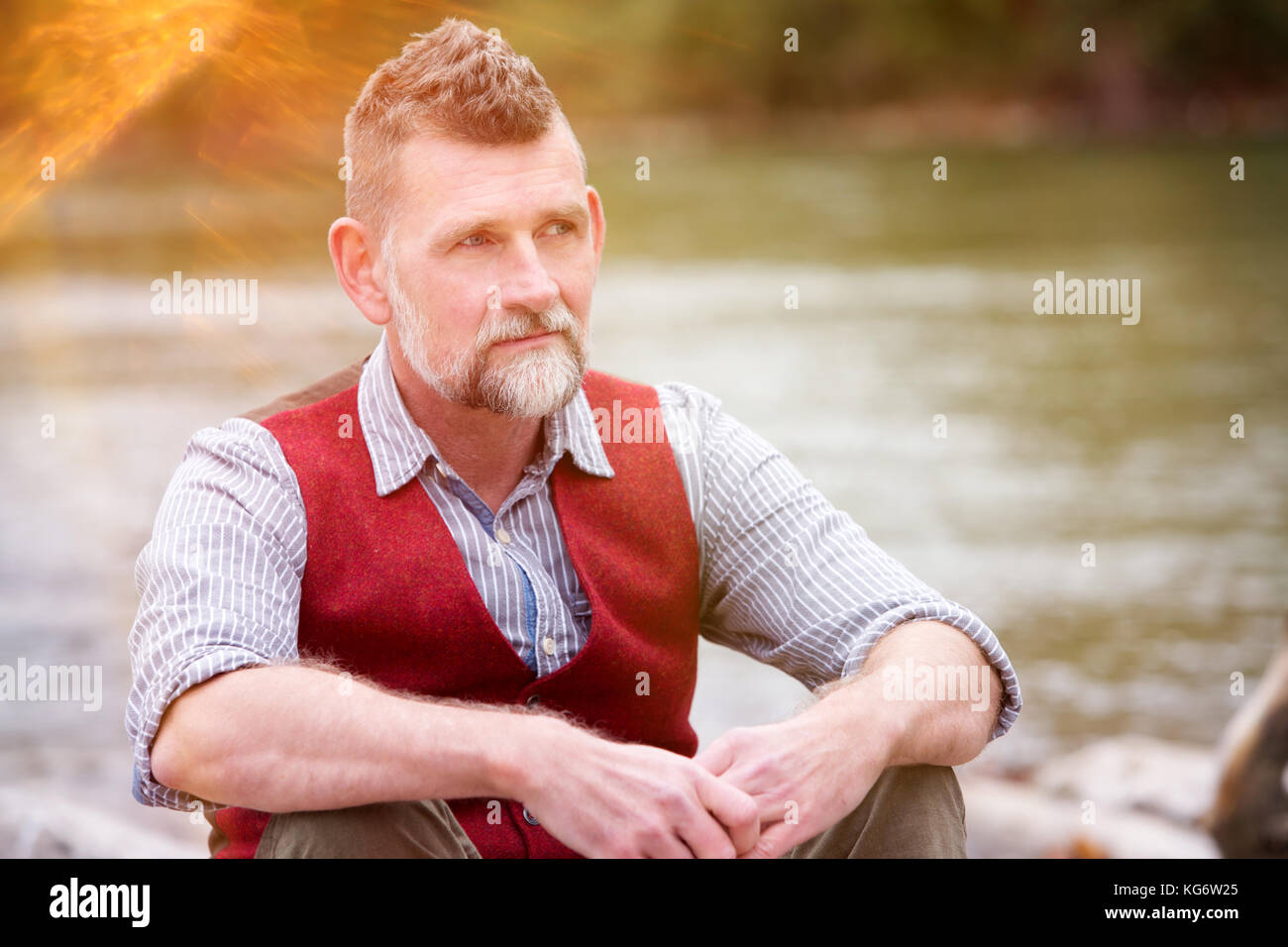 portrait of handsome man in his 50s sitting by the river Stock Photo ...