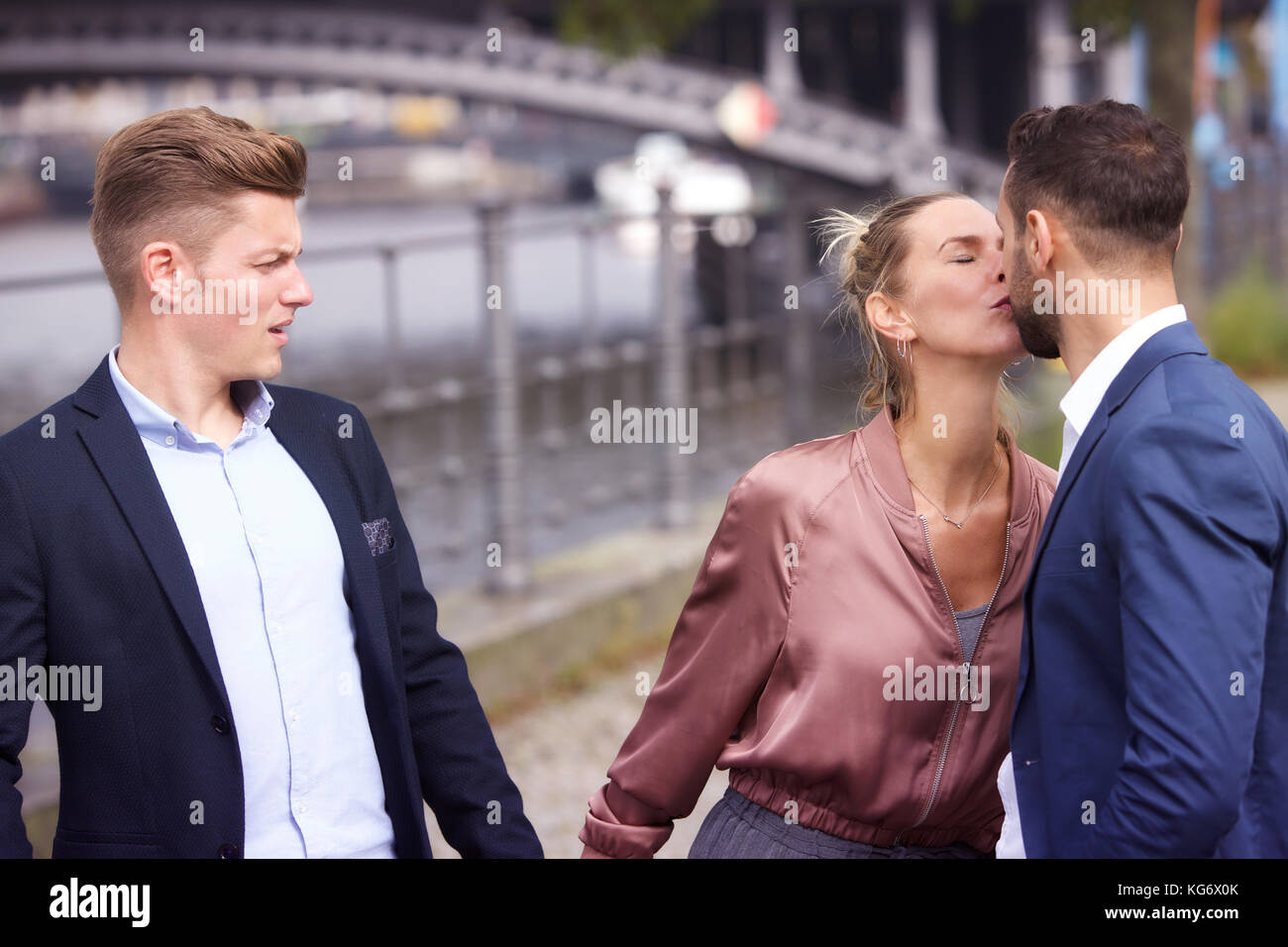 woman kissing man while another is upset and watching Stock Photo - Alamy