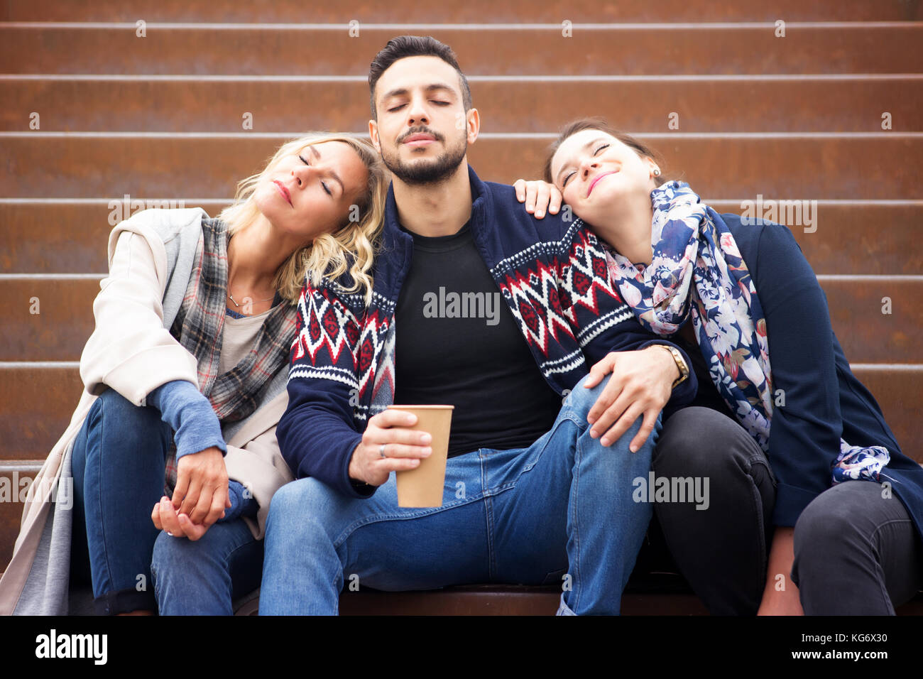 group of friends sitting outside on stairs and enjoying the sun Stock ...
