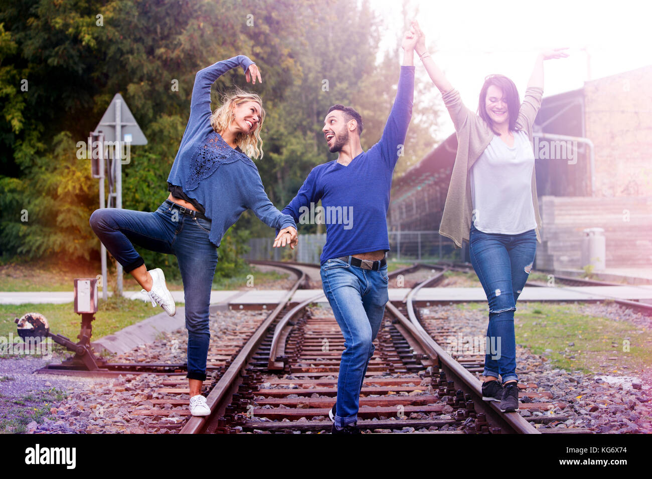 three friends walking on train tracks and having fun Stock Photo - Alamy