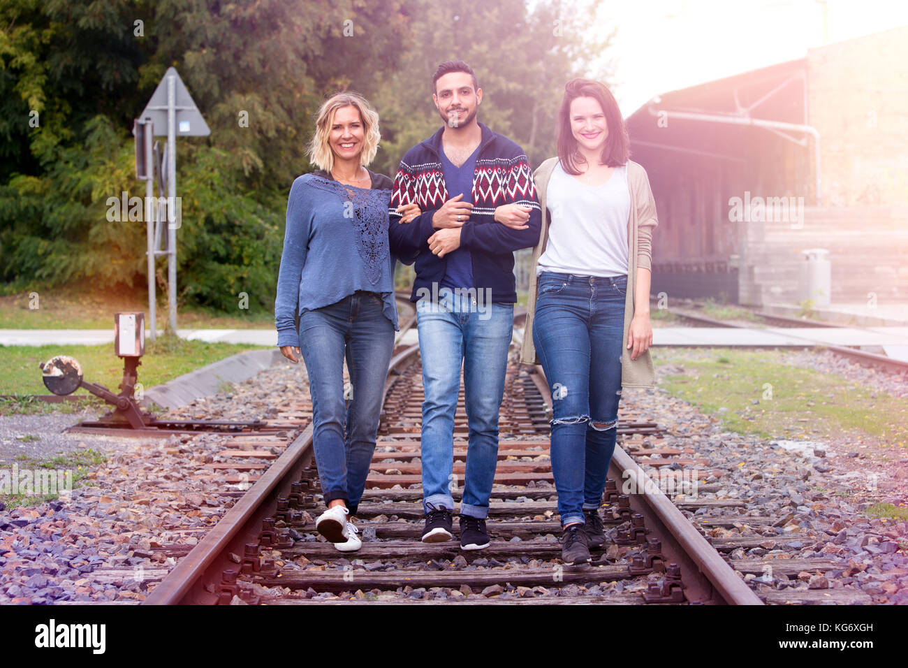 three friends walking on train tracks and having fun Stock Photo - Alamy