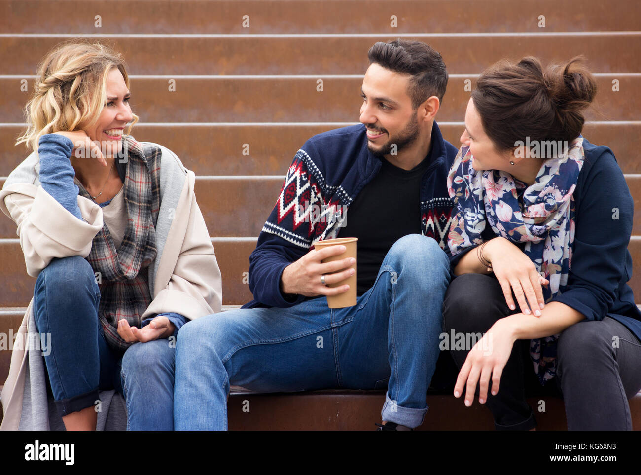 group of friends sitting outside on stairs and smiling Stock Photo - Alamy