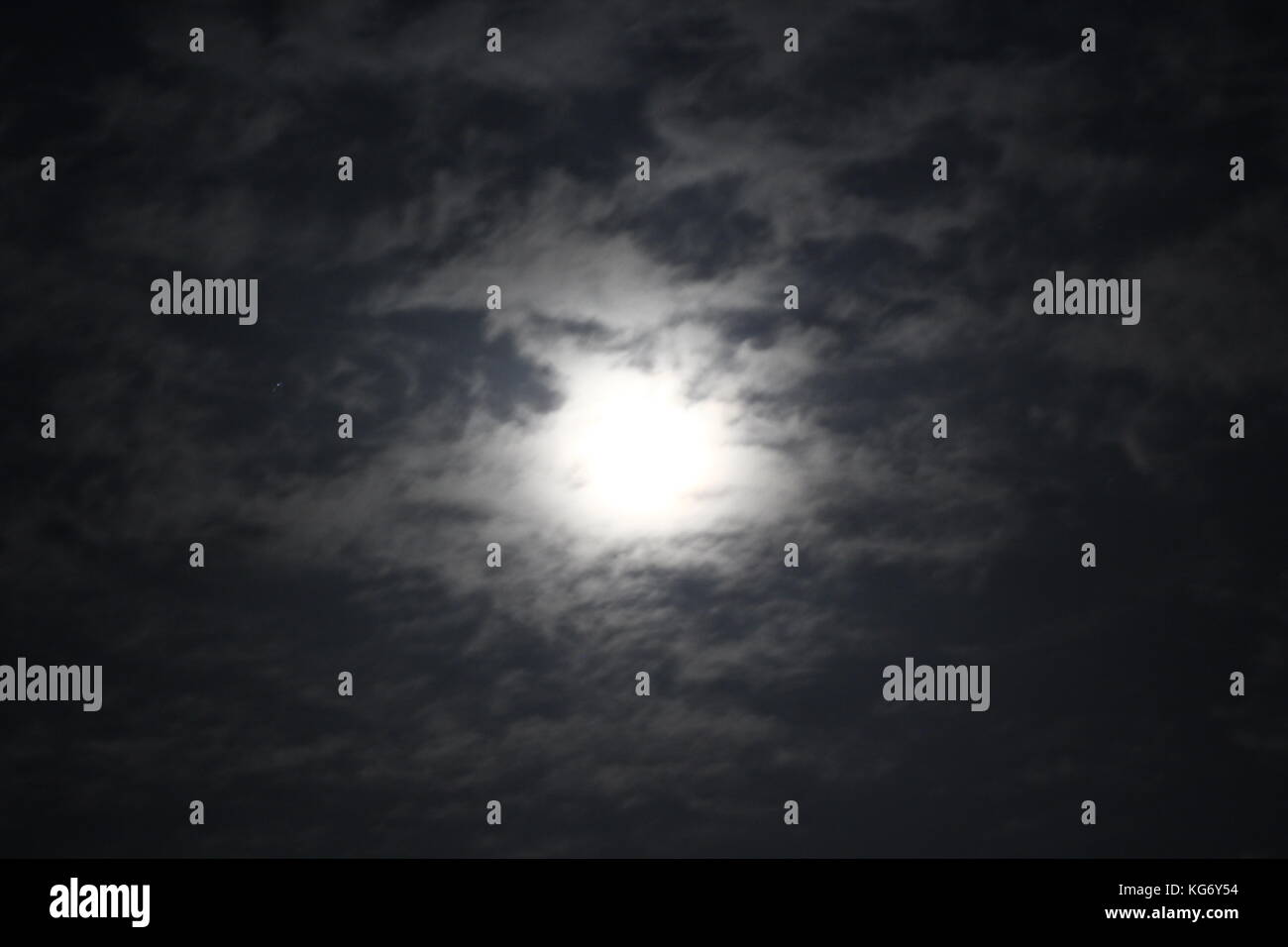 Photo of bright moon on a clouded night Stock Photo - Alamy