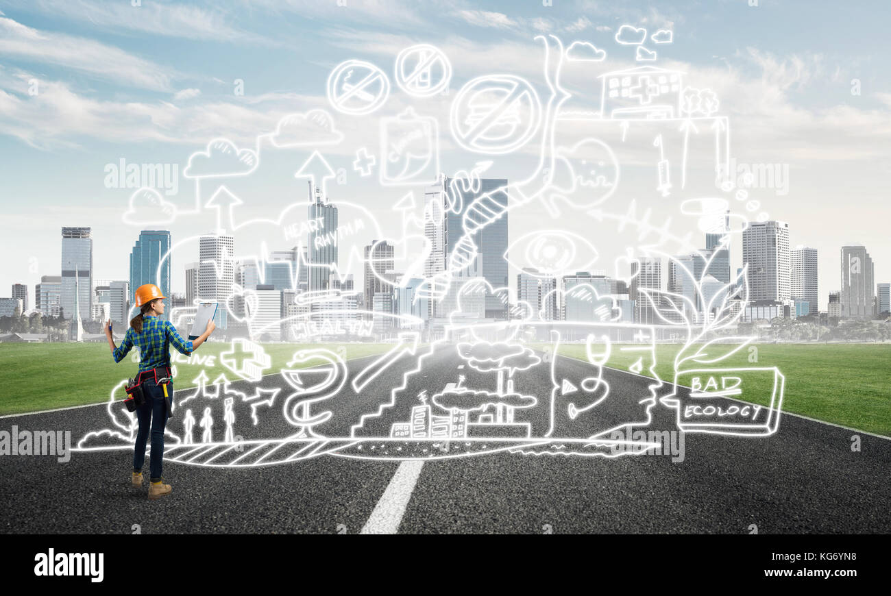 Back view of engineer woman in hardhat outdoor and sketched concept on ...