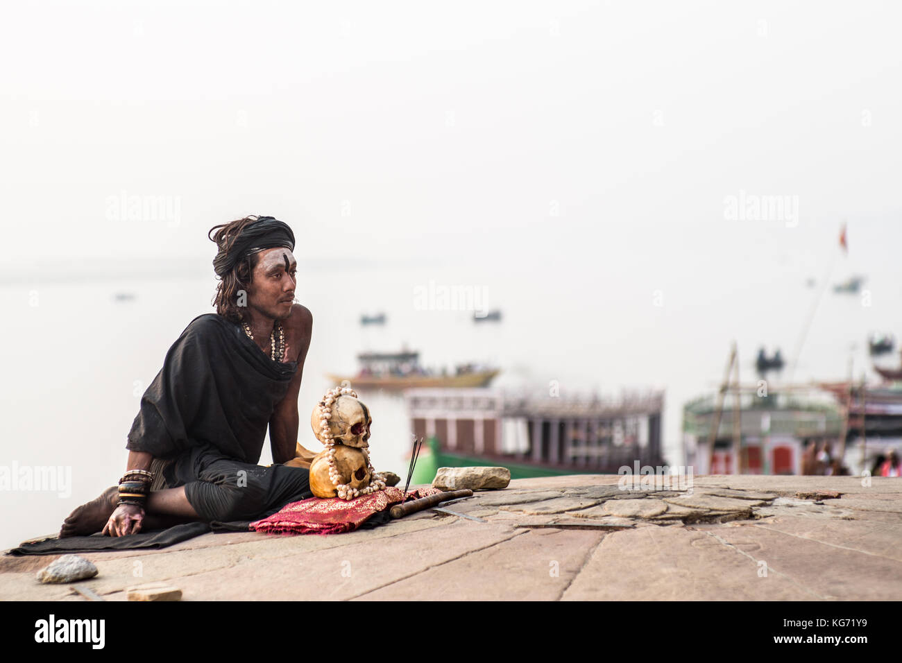 An Agori-yogi (hindu devotee) sitting with his human skulls next to the ...