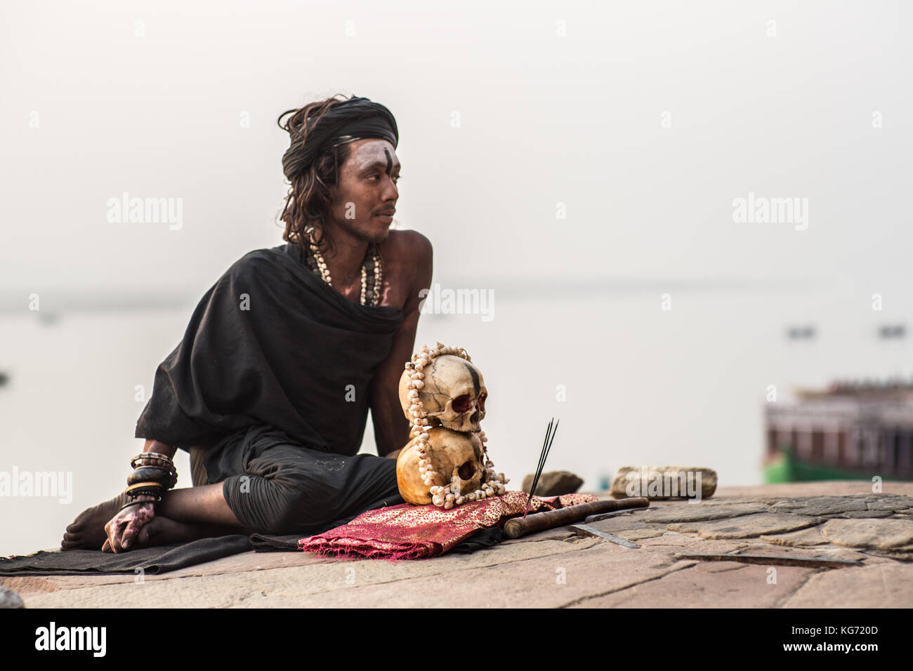 An Agori-yogi (hindu devotee) sitting with his human skulls next to the ...