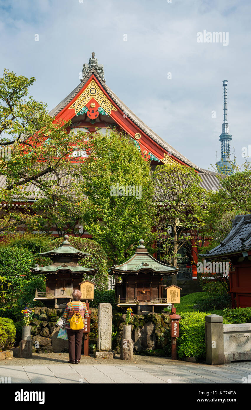 Tradition and Modernity in Japan. People pray in an old temple below ...