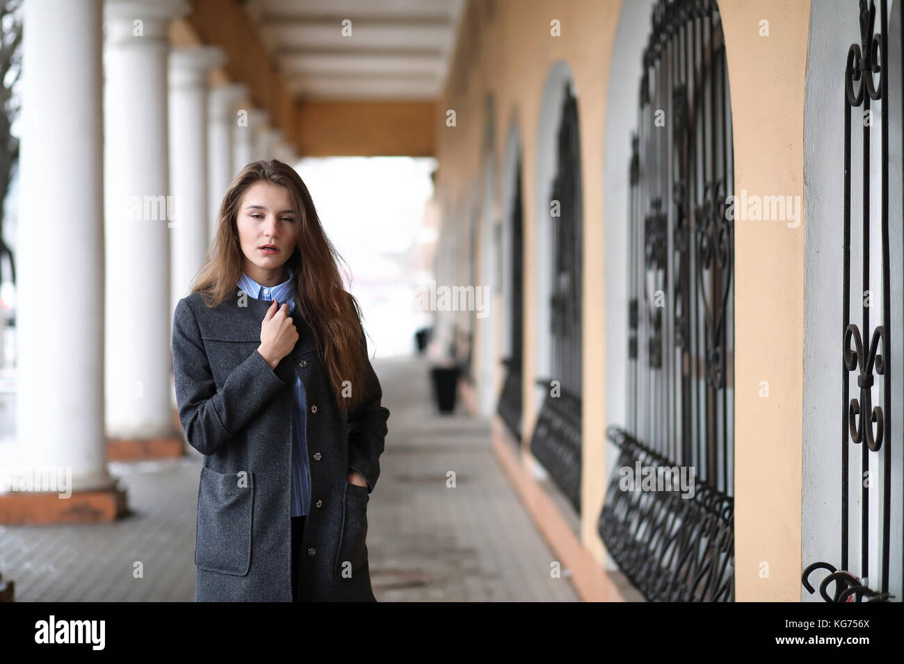 Young beautiful girl on a walk near a building with a column Stock ...