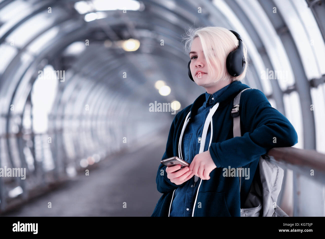 Young student listening to music in big headphones in the subway Stock ...