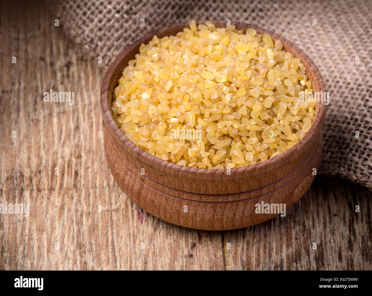 Raw Bulgur (on wooden background) as detailed close-up shot Stock Photo ...