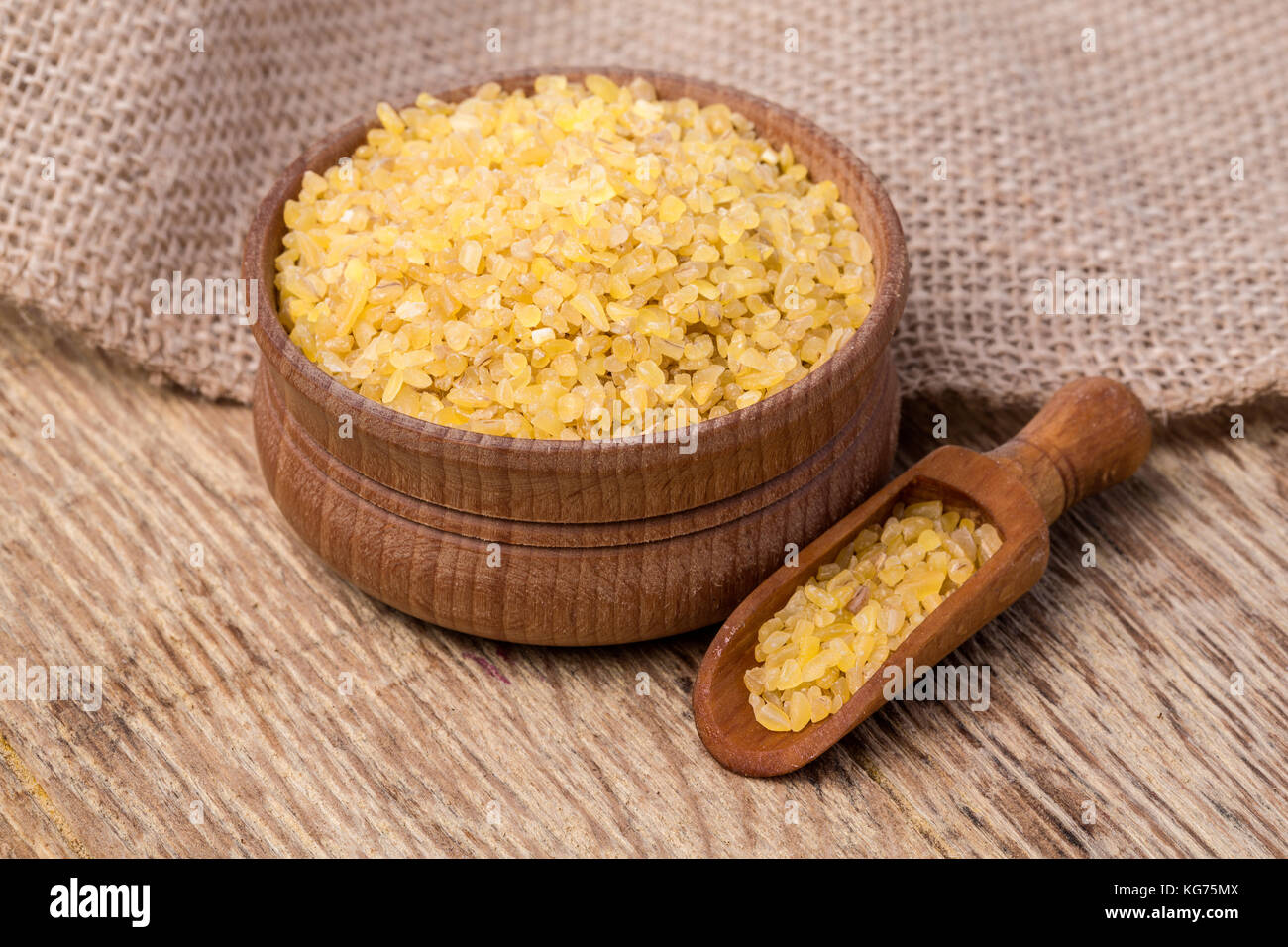 Raw Bulgur (on wooden background) as detailed close-up shot Stock Photo ...