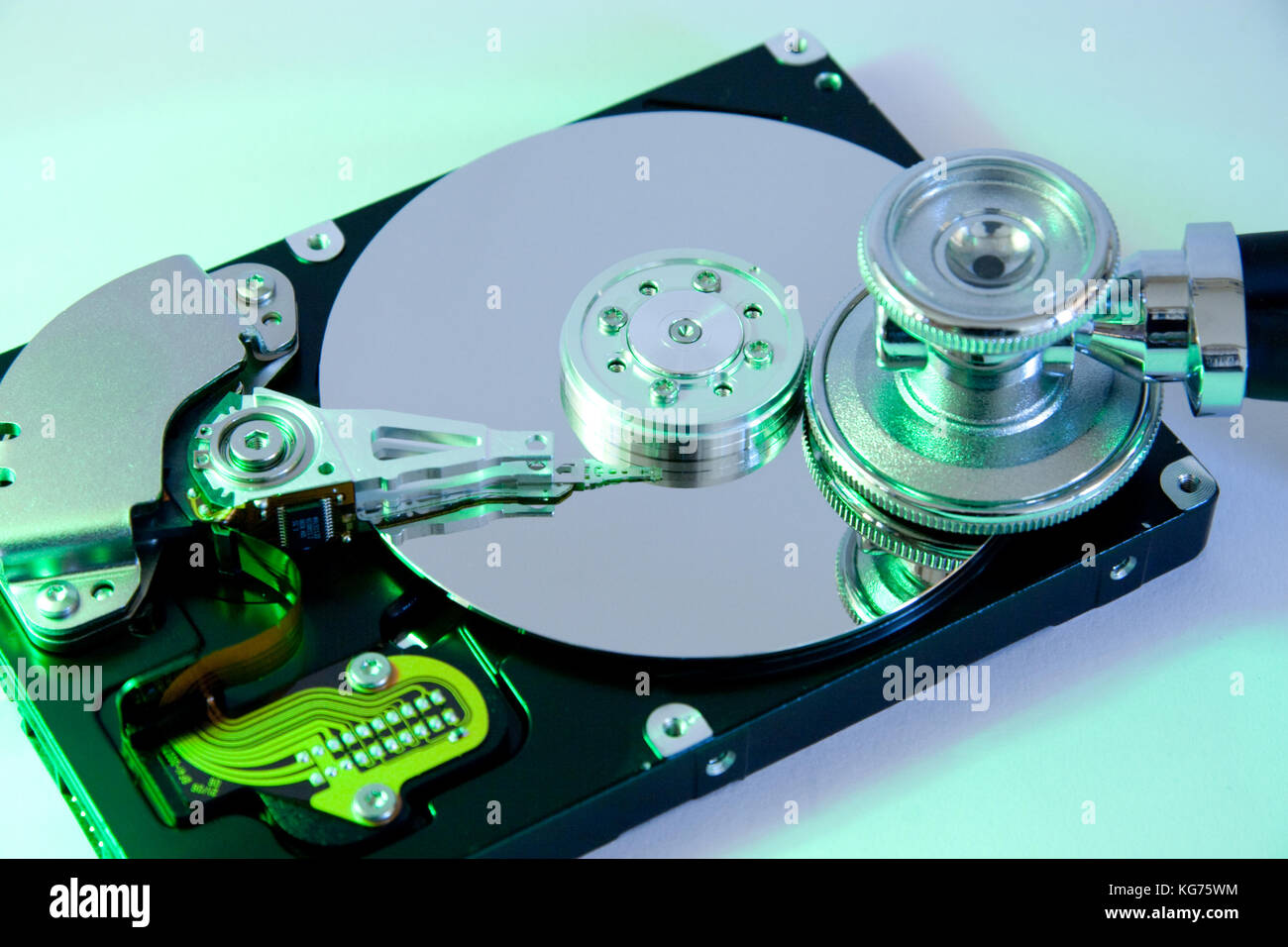 open computer hard disk with stethoscope and green light on white ...
