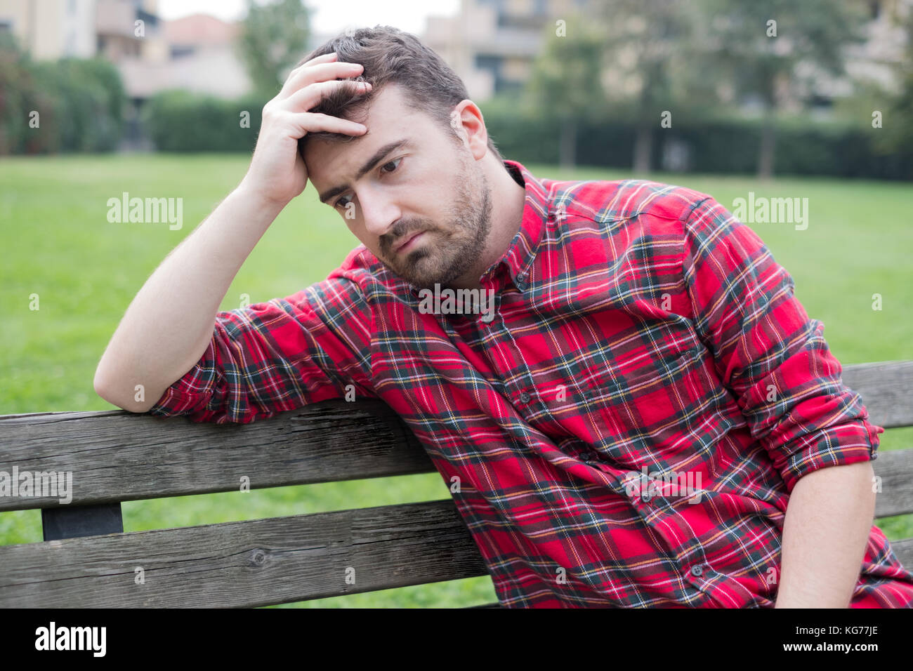 Sad and lonely man without a job seated on a park bench Stock Photo - Alamy