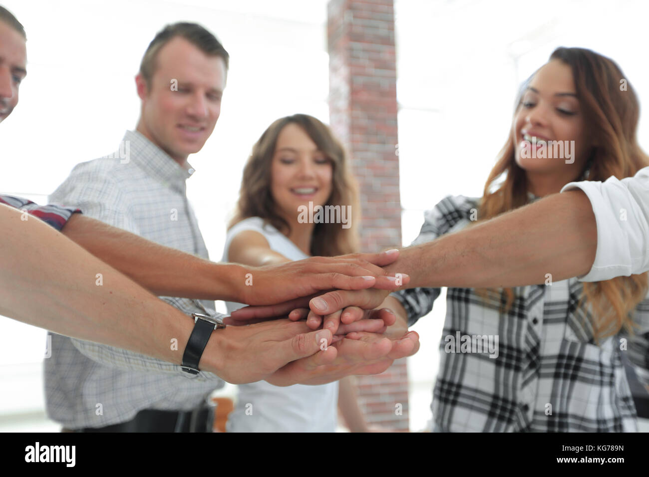 .friendly team of designers clasped their palms together Stock Photo ...